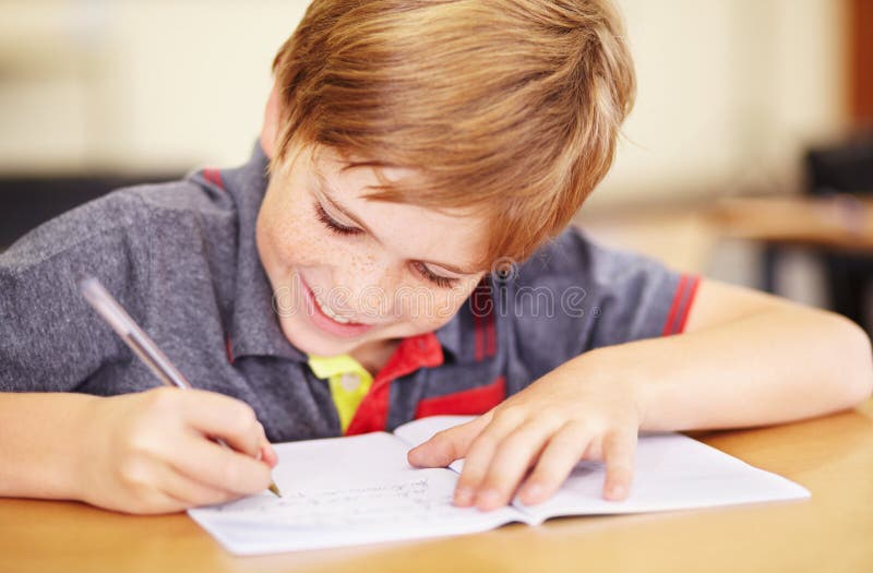 School, Education and a Student Boy Writing in a Book while Sitting at ...