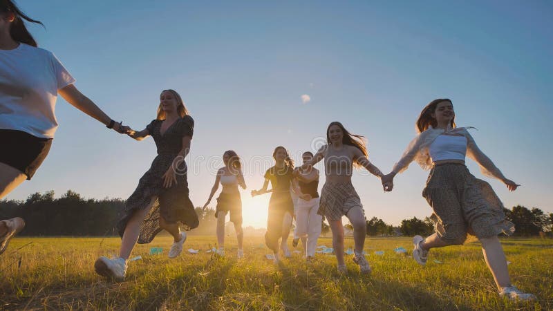 School Friends Run Off into the Sunset Holding Hands Under Scattered ...