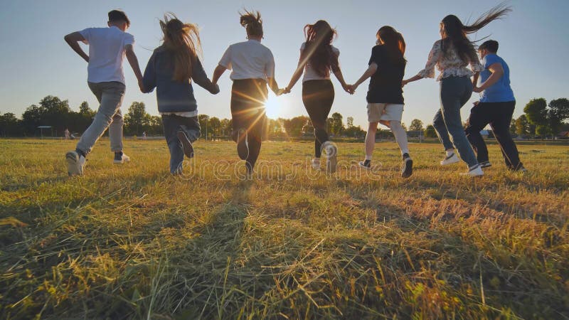 School Friends Running Across the Field Holding Hands at Sunset. Stock ...