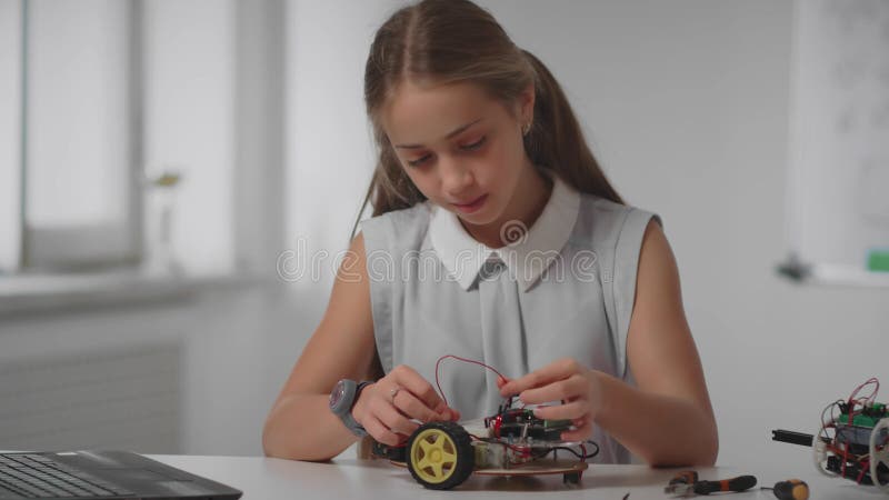 School Girl Constructing Robotic Bot Machine at Table in Modern ...