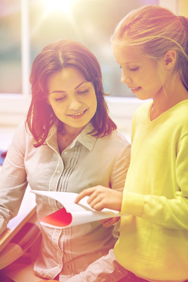 School Girl with Notebook and Teacher in Classroom Stock Photo - Image ...
