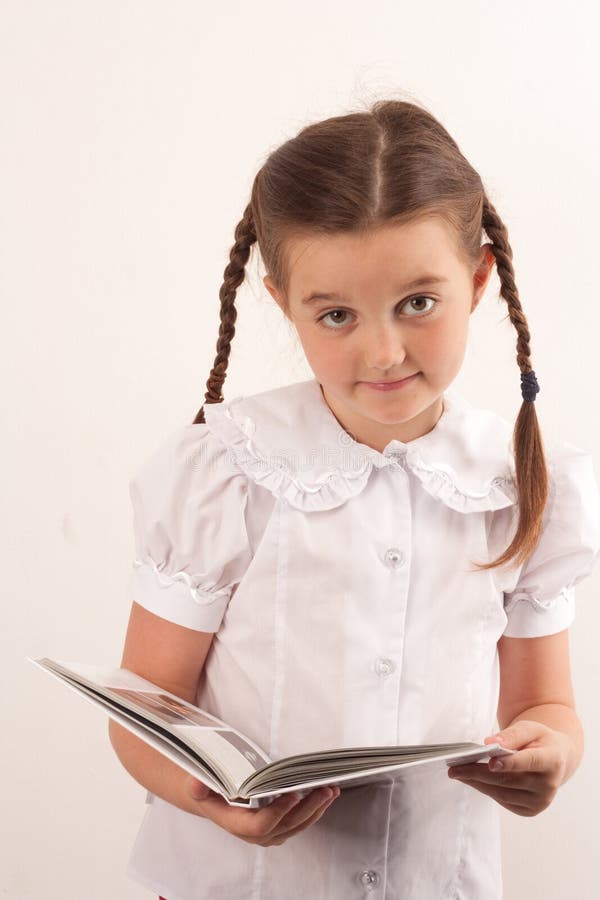 School Girl Reading Book and Looking at the Camera Stock Photo - Image ...
