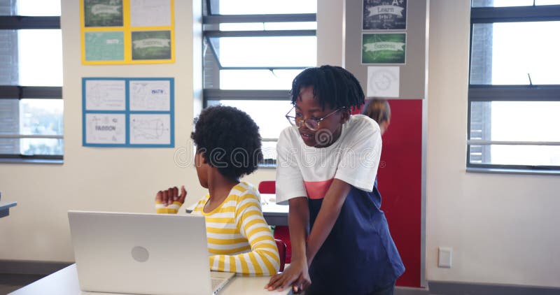 In School, Girl Students Collaborating on Project Using Laptop in ...