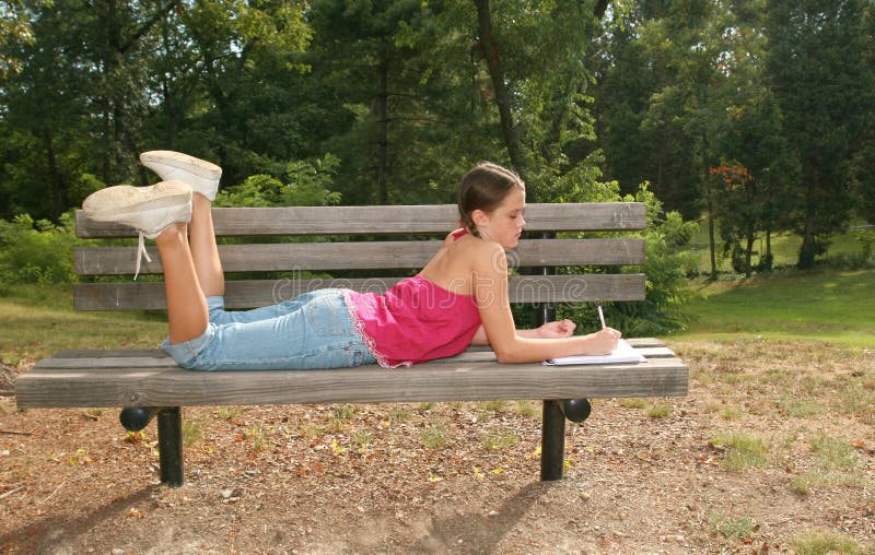 School Girl Writing in Notebook on a Bench Stock Photo - Image of young ...