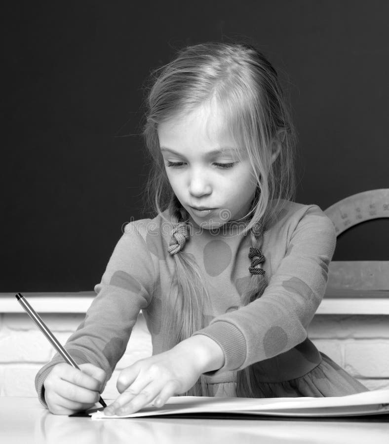 School Girl Writing in Notepad and Doing School Homework. Thinking ...