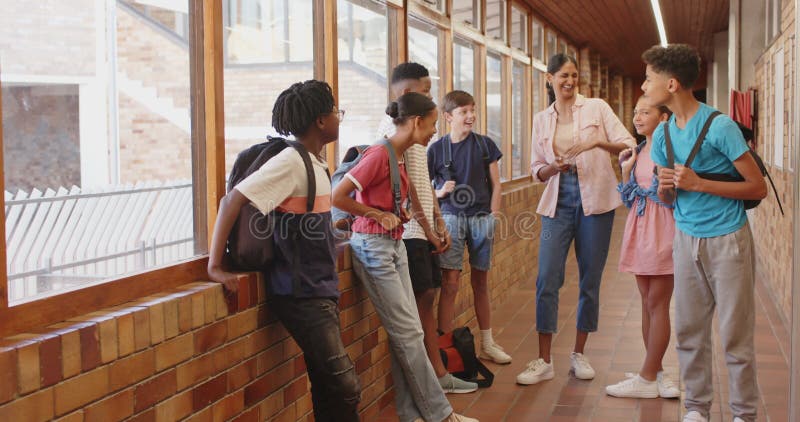 In School Hallway, Group of Students Talking and Laughing with Teacher ...