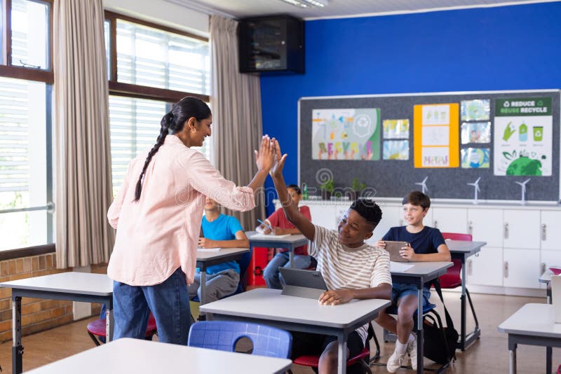 In School, Indian Female Teacher Giving High-five To Student Using ...