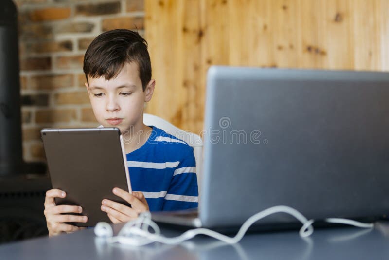 School Kid Using Laptop while Doing Schoolwork at Home. Homeschooling ...