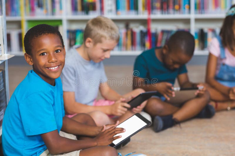 School Kids Sitting on Floor Using Digital Tablet in Library Stock ...
