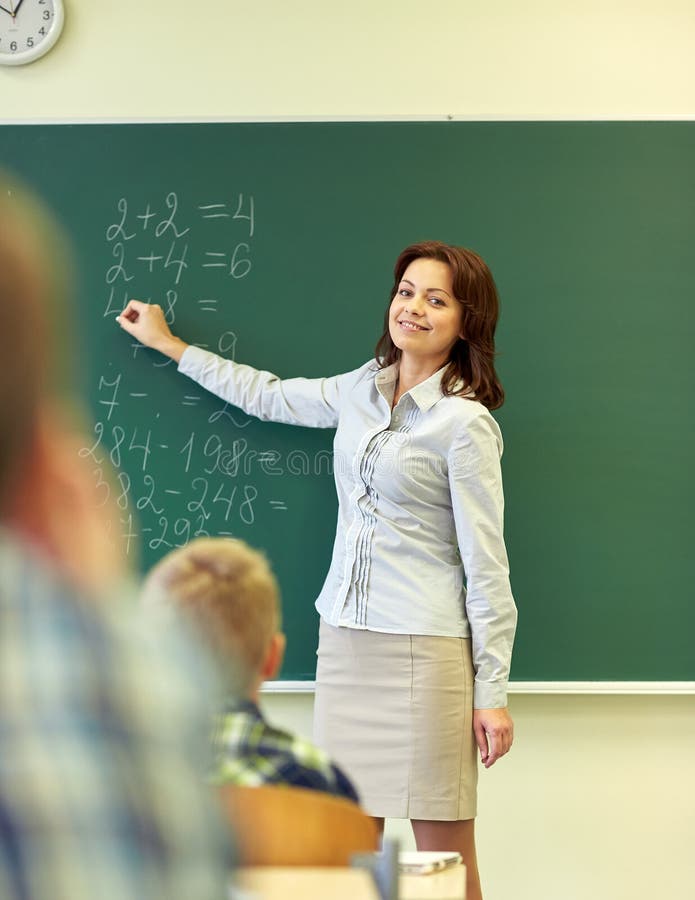 School Kids and Teacher Writing on Chalkboard Stock Photo - Image of ...