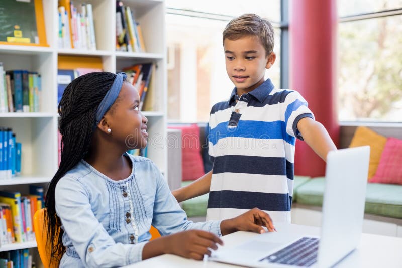 School Kids Using a Laptop in Library Stock Photo - Image of indoors ...