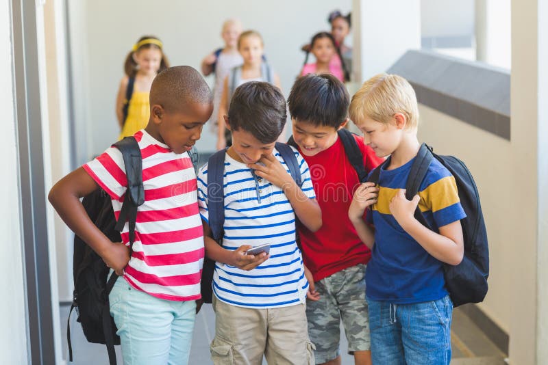 School Kids Using Mobile Phone in Corridor Stock Photo - Image of kids ...