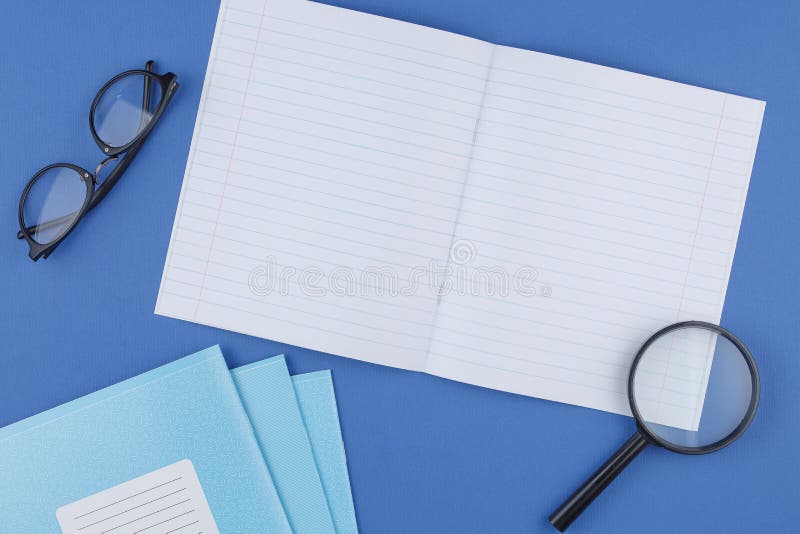 School Notebook with Magnifier on Blue Table Stock Photo - Image of ...