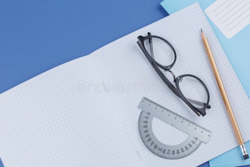 School Notebook with Pen and Glasses on Blue Table Stock Image - Image ...
