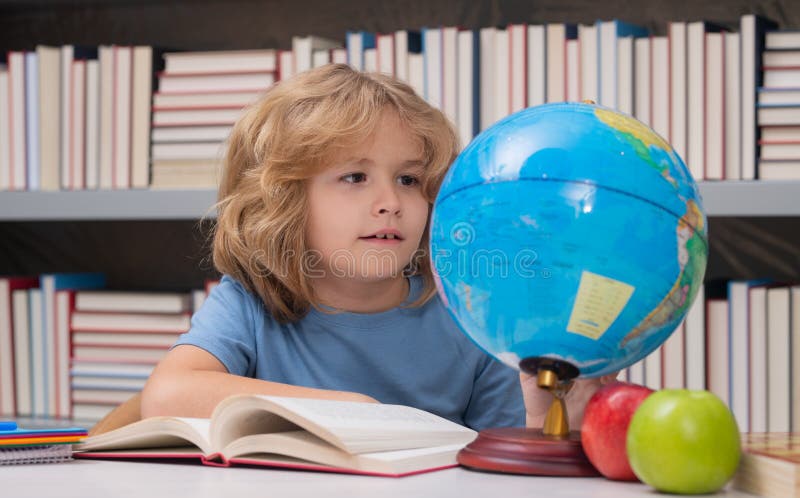 School Pupil Looking at Globe in Library at the Elementary School ...