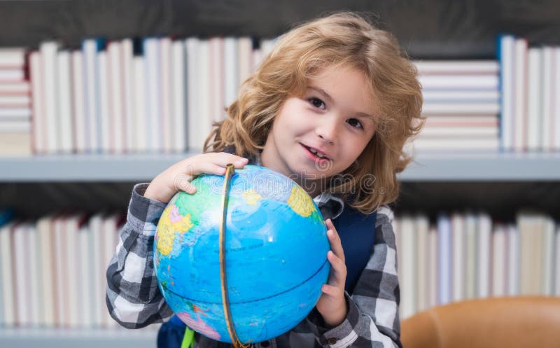 School Pupil Looking at Globe in Library at the Elementary School ...