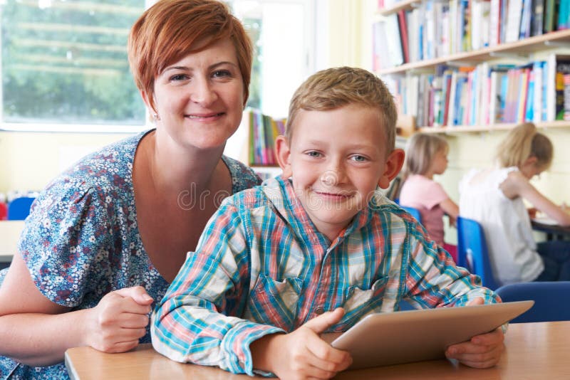 School Pupil with Teacher Using Digital Tablet in Classroom Stock Photo ...