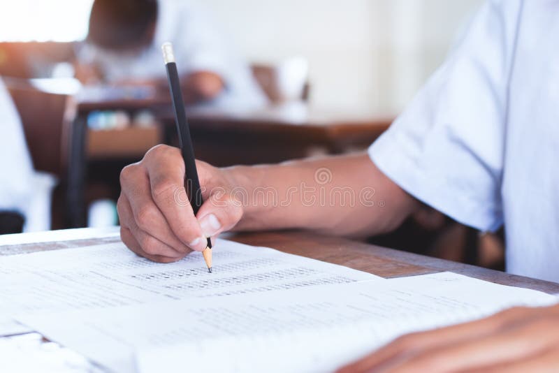 School Student is Taking Exam and Writing Answer in Classroom for ...
