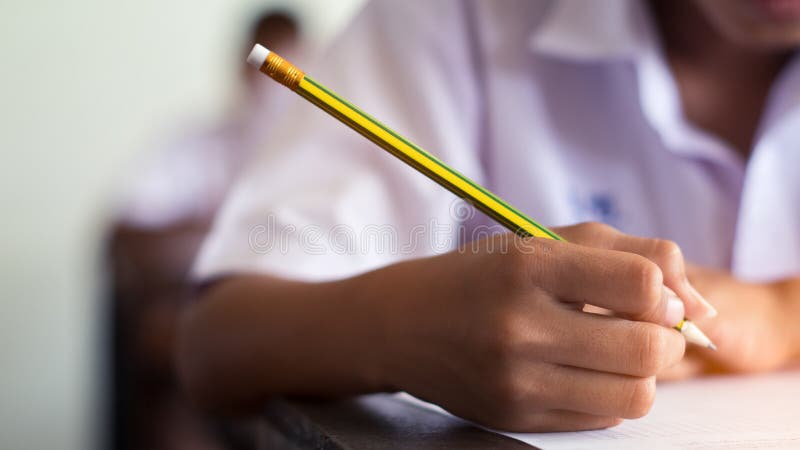 School Student is Taking Exam and Writing Answer in Classroom for ...