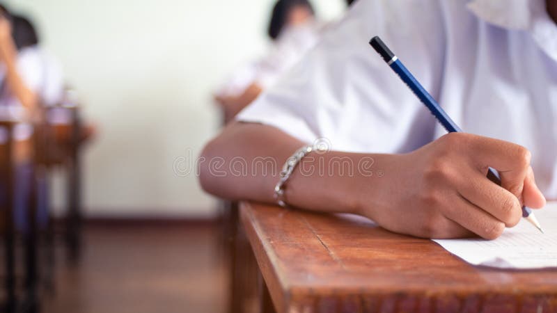 School Student is Taking Exam and Writing Answer in Classroom for ...