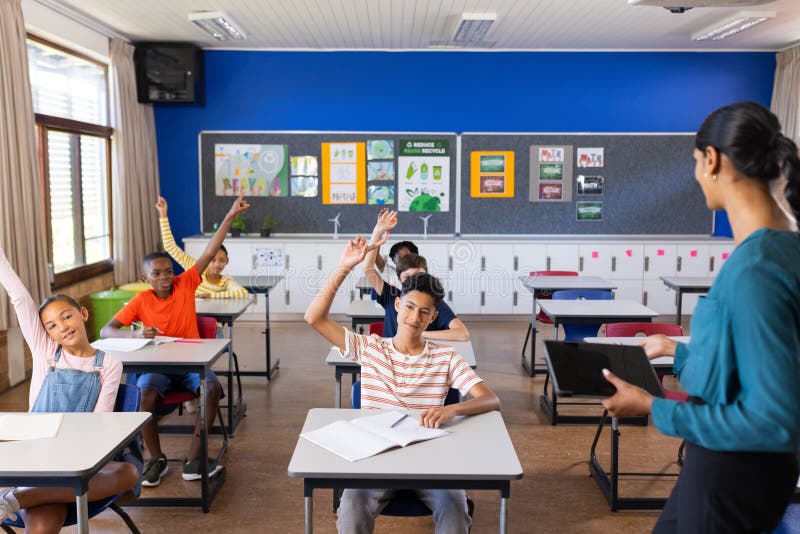 In School, Students Raising Hands in Classroom while Indian Female ...
