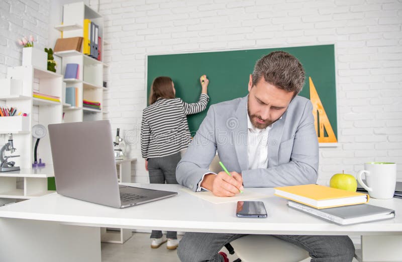 School Teacher in Classroom with Selective Focus of Kid at Blackboard ...