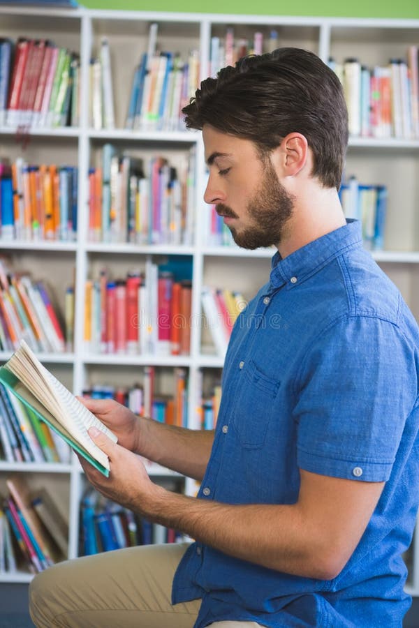 School Teacher Reading Book in Library Stock Photo - Image of bookshelf ...