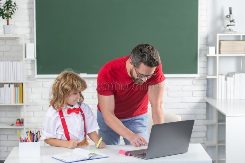School Teacher with a Schoolboy Learning at Laptop Computer, Studying ...
