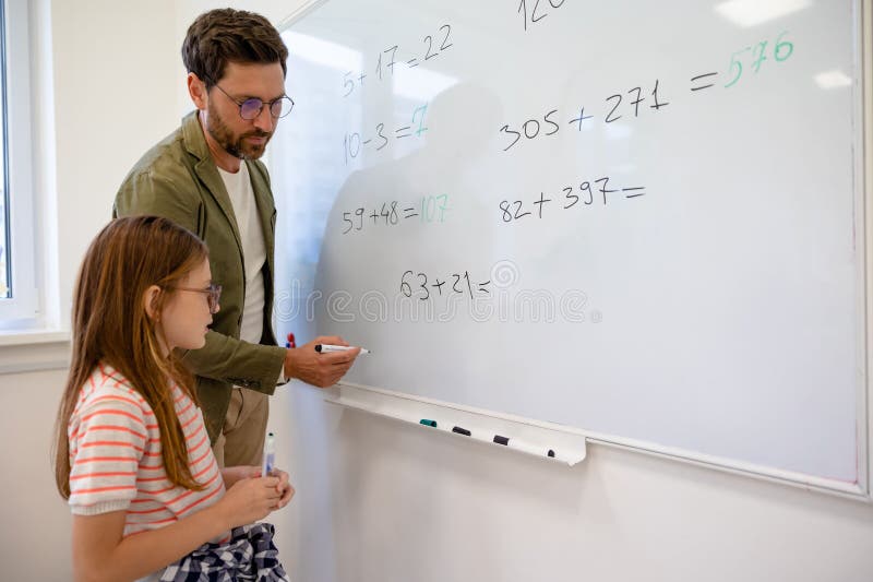 School Teacher Watching Pupil Writing on White Board in Classroom ...