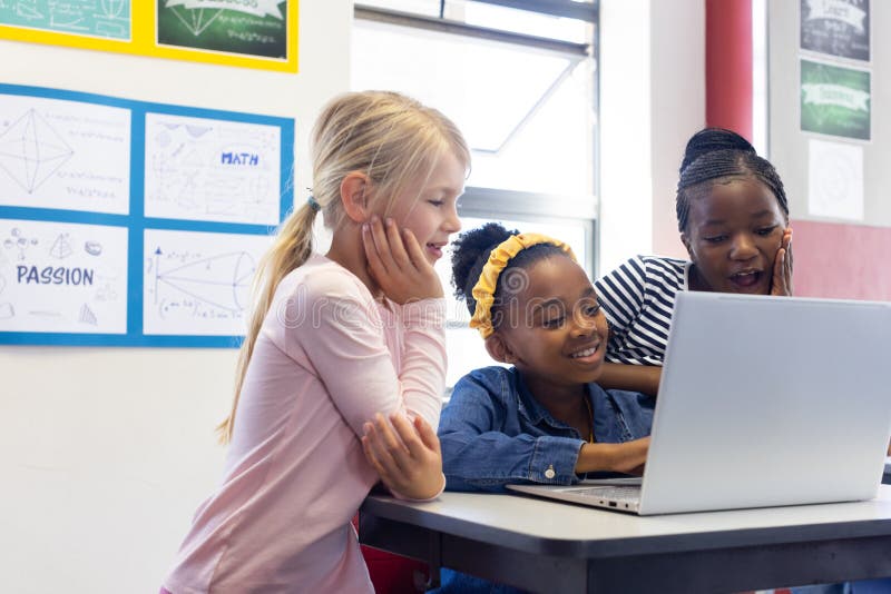 In School, Three Multiracial Girls Using Laptop Together in Classroom ...