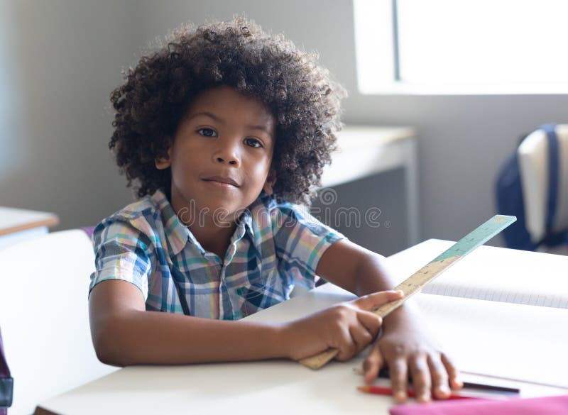 In School, Young Boy Holding Ruler at Desk, Looking Confidently at ...