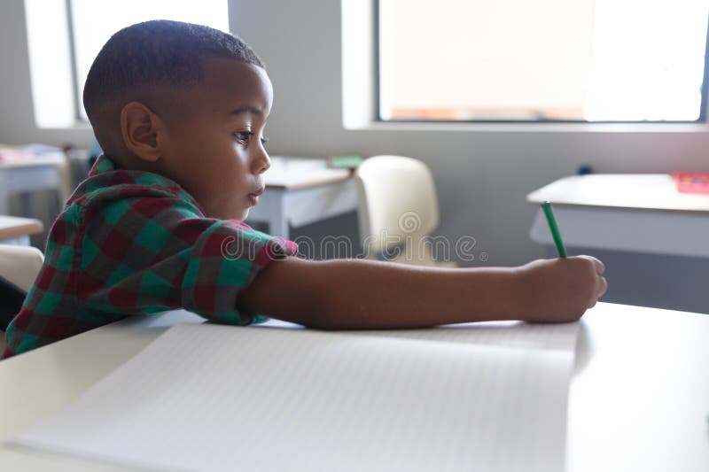 In School, Young Boy Writing in Notebook, Concentrating in Classroom ...