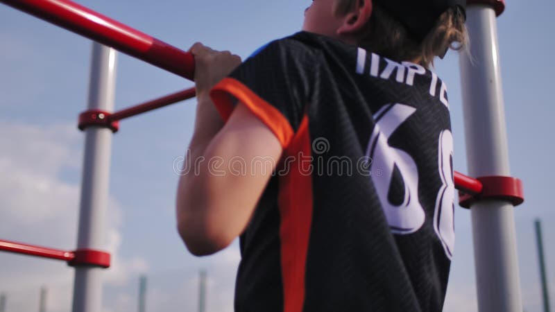 Schoolboy in Activewear Performing Pull Ups on Playground Stock Footage ...