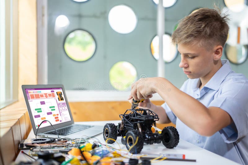 Schoolboy Carefully Using Pliers Fixing Robotics Car in STEM Class ...
