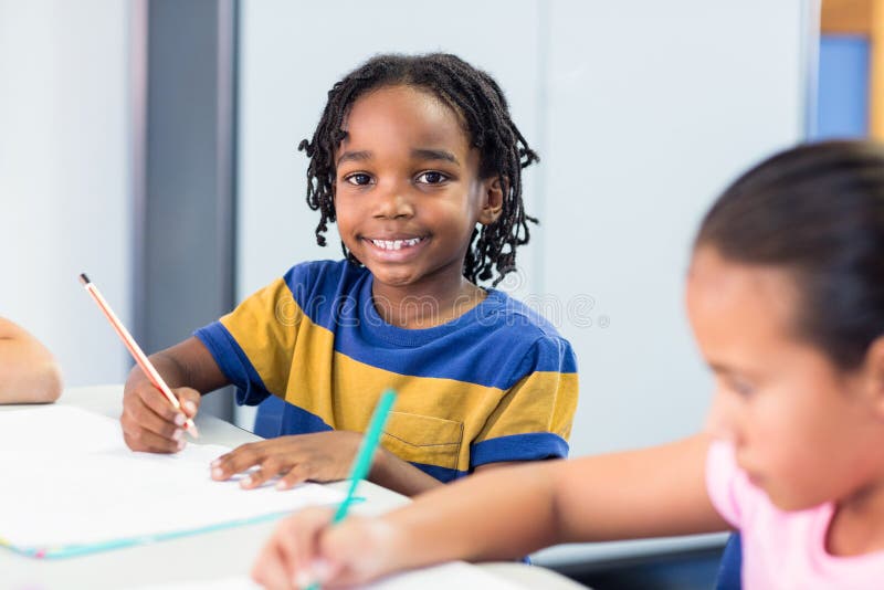 Schoolboy with Classmate Writing on Book Stock Photo - Image of female ...