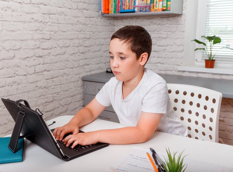 Schoolboy Doing His Homework in Notebook with Laptop Computer at Home ...