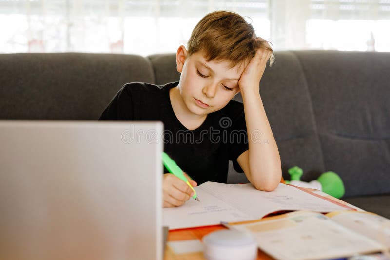 Schoolboy Doing Homework on Laptop. Frustrated Boy Writing in a ...