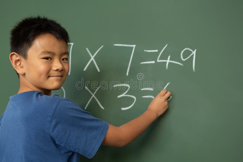 Schoolboy Doing Math on Greenboard in a Classroom Stock Photo - Image ...