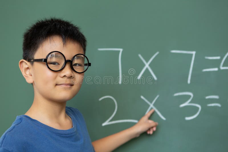 Schoolboy Doing Math on Greenboard in a Classroom Stock Photo - Image ...