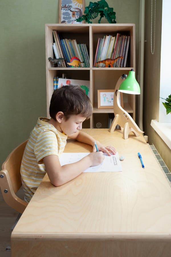A Schoolboy Doing Math Lesson Sitting at Desk in the Children Room ...