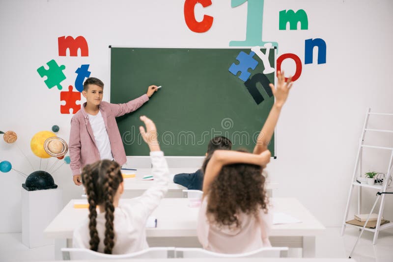 Schoolboy Holding Chalk and Pointing at Blackboard Stock Image - Image ...
