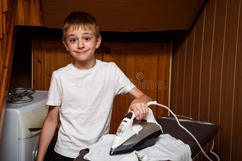 Schoolboy Irons His Clothes Electric Iron. Child Does Homework Stock ...