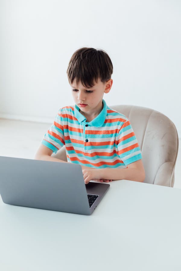 Schoolboy Learning Games at the Table with Laptop Online Stock Photo ...