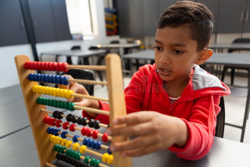 Schoolboy Learning Math with Abacus at Desk in a Classroom Stock Photo ...