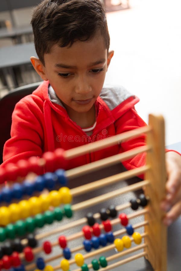 Boy Learning Math with Abacus Against Green Chalkboard in a Classroom ...