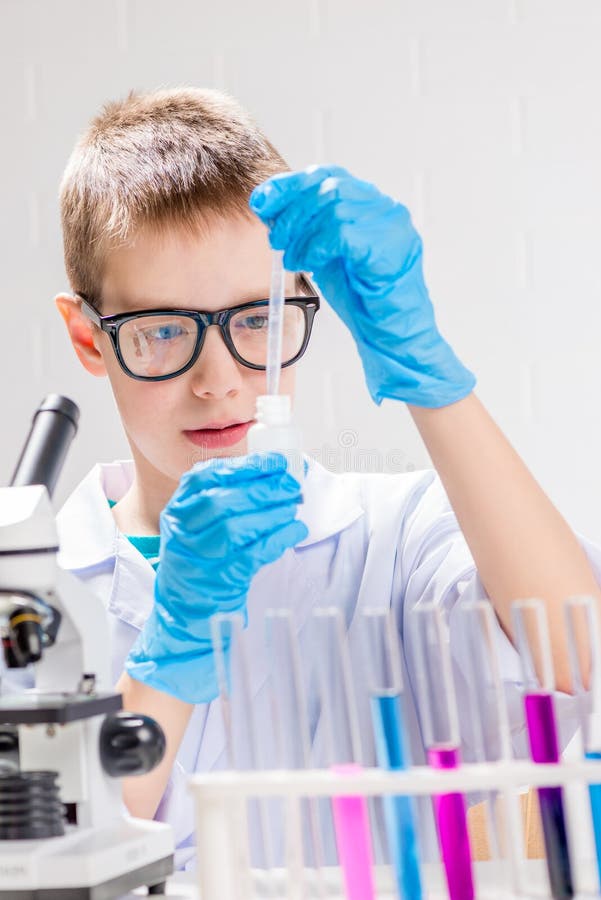 A Schoolboy with a Microscope Examines Chemicals in Test Tubes ...