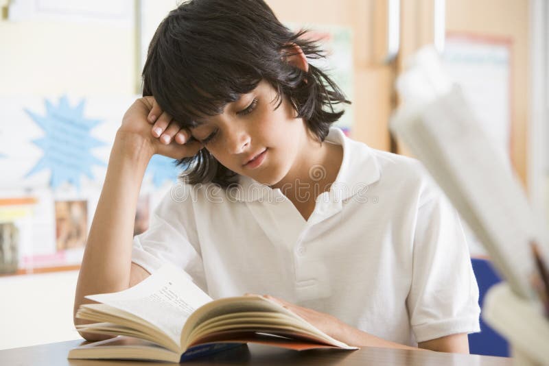 Schoolboy Reading a Book in Class Stock Photo - Image of indoors ...