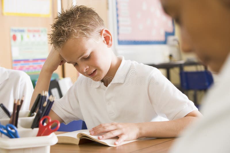 Schoolboy Reading a Book in Class Stock Photo - Image of concentration ...