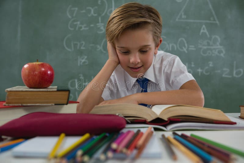 Schoolboy Reading Book in Classroom Stock Photo - Image of pencil ... Schoolboy Reading Book in Classroom Stock Photo - Image of pencil ...