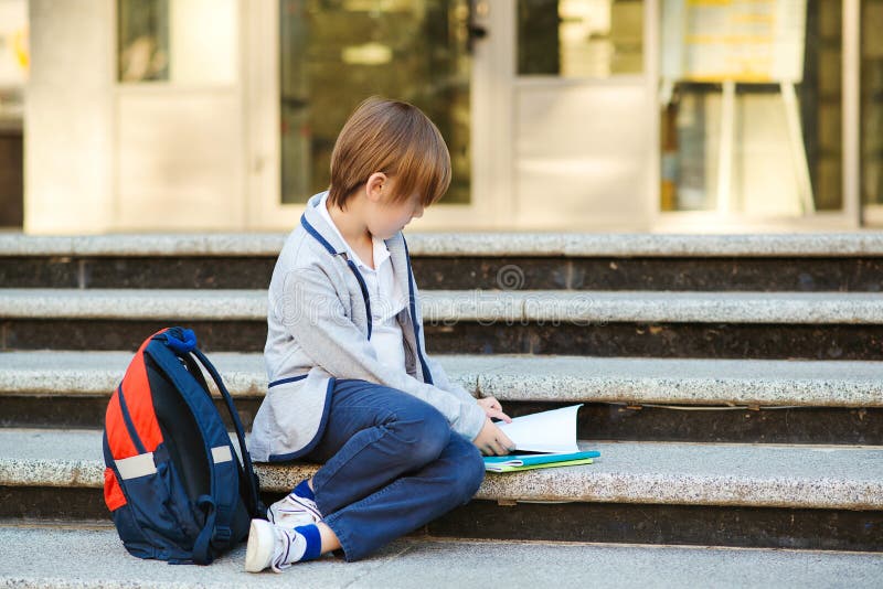 Schoolboy Reading Book Sitting on Stairs. Beginning of Lessons. First ...